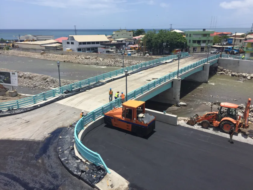 First coat of tar rolled onto Roseau's new West Bridge - WIC News